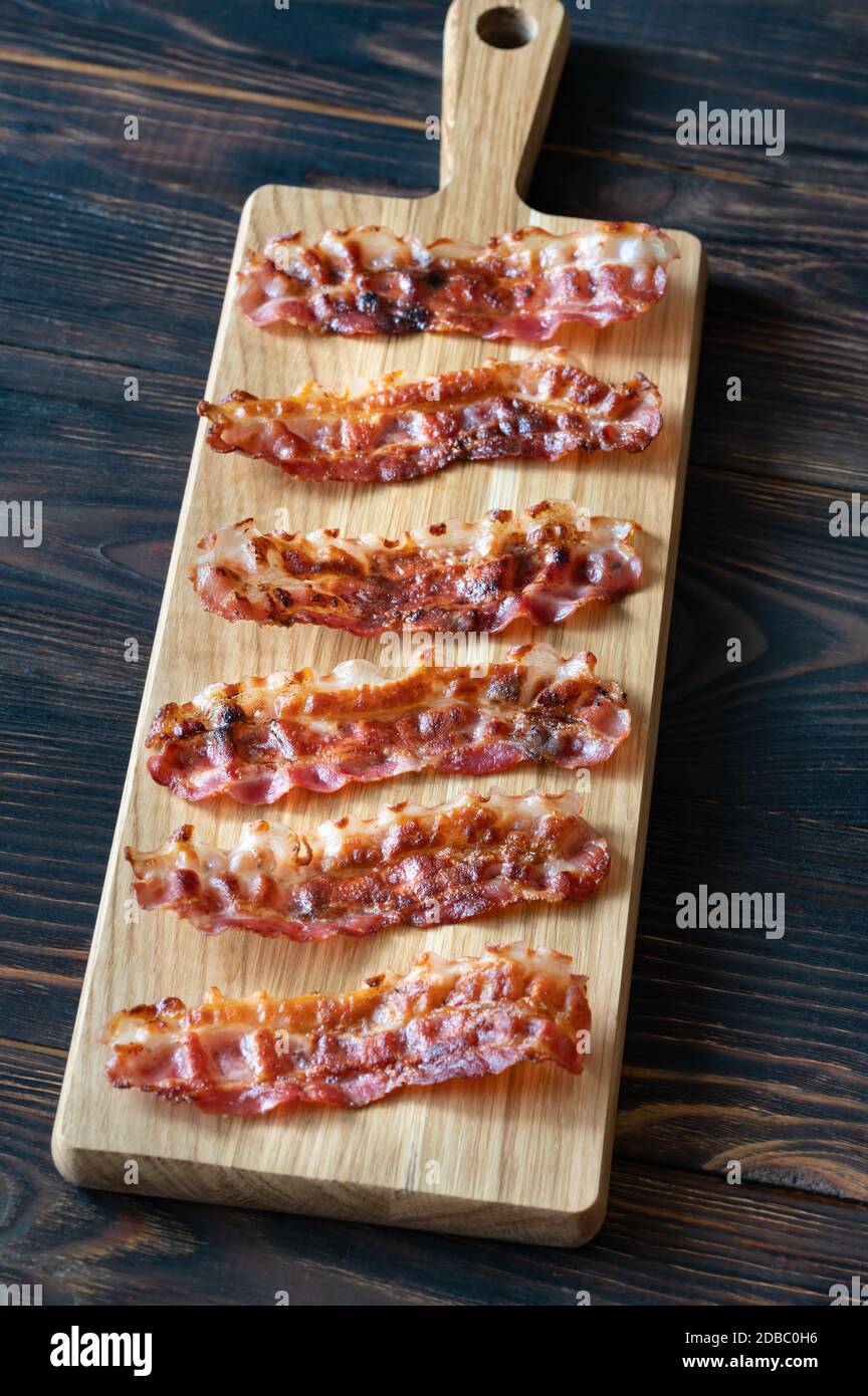 Fried bacon strips on the wooden board Stock Photo - Alamy