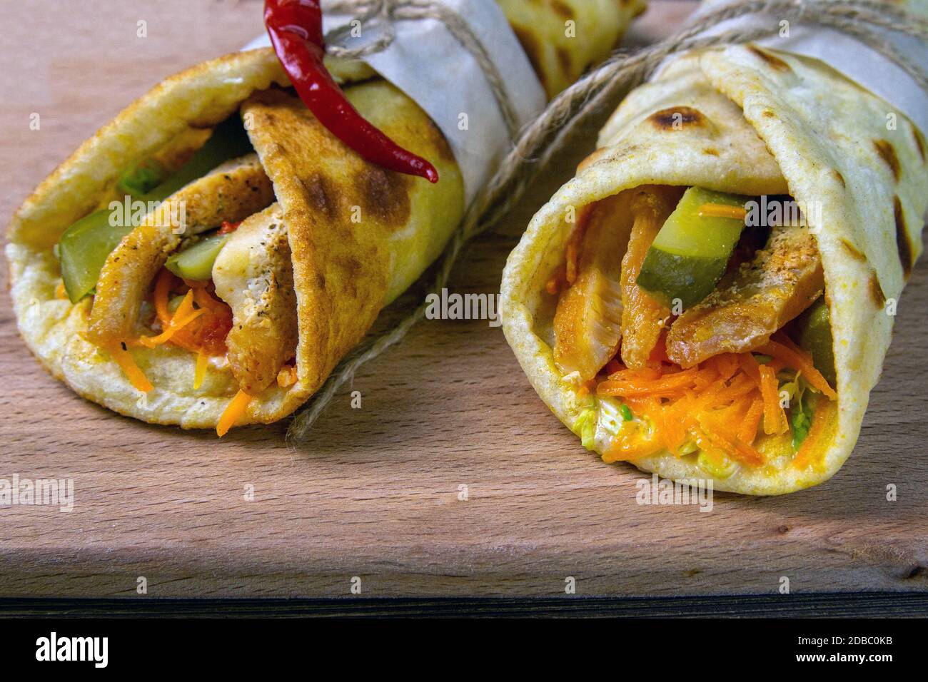 Two doner kebab with meat, vegetables and fries in pita bread close-up ...