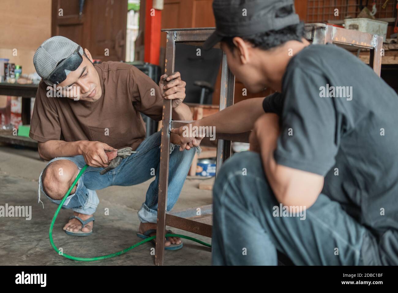 customer shows with finger pointing of part to be welded to welder in ...