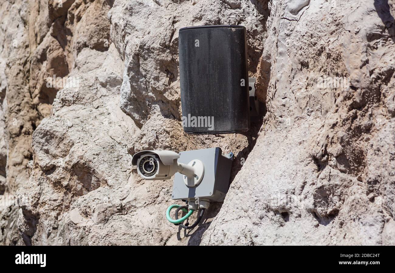 CCTV camera system placed on the rock wall near a speaker Stock Photo ...