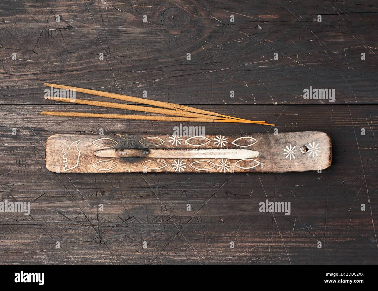stack of incense sticks for rituals and a stand on a brown wooden table ...