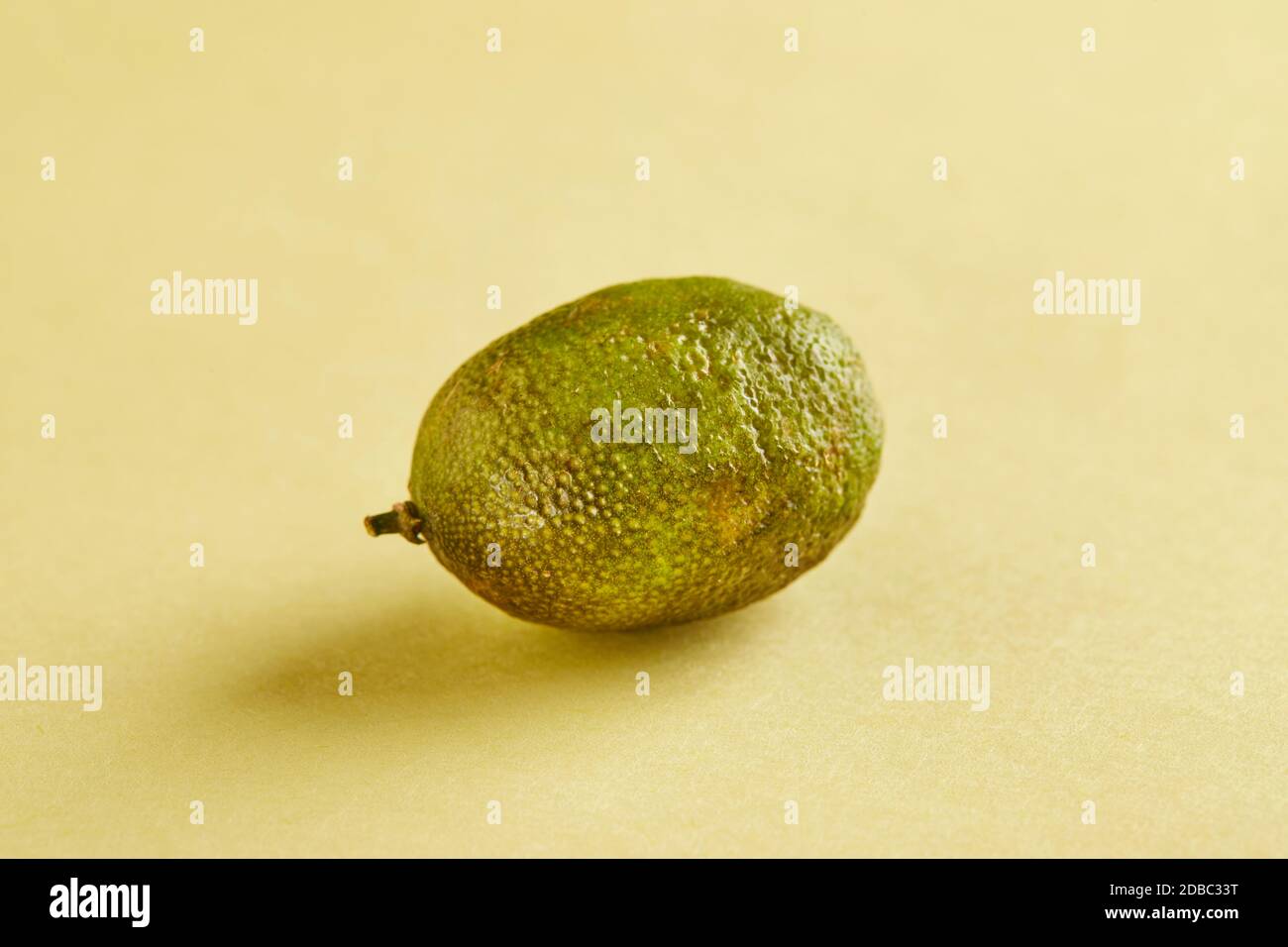 Ripe fresh mini lemon on a yellow background with shadow Stock Photo ...