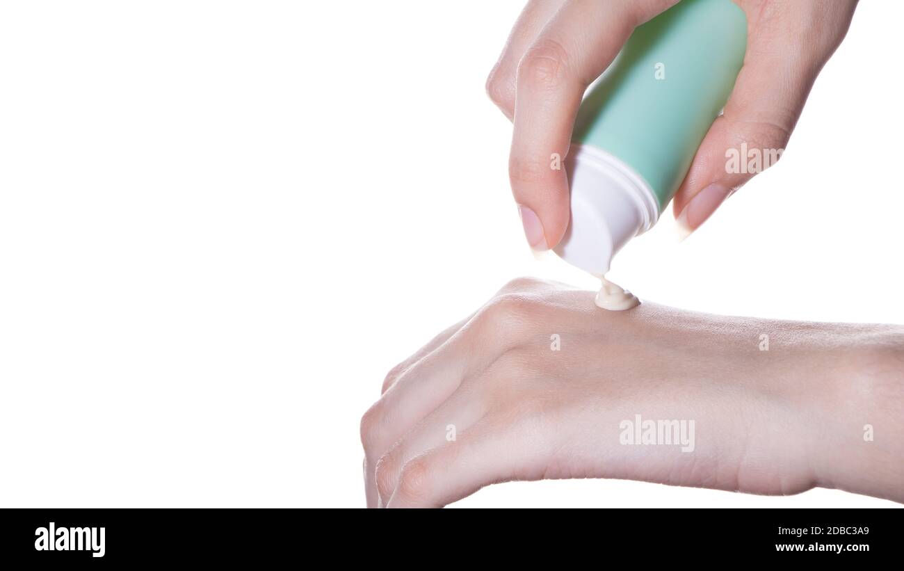 The girl applies a moisturizer or lotion to the skin of the hand on a ...