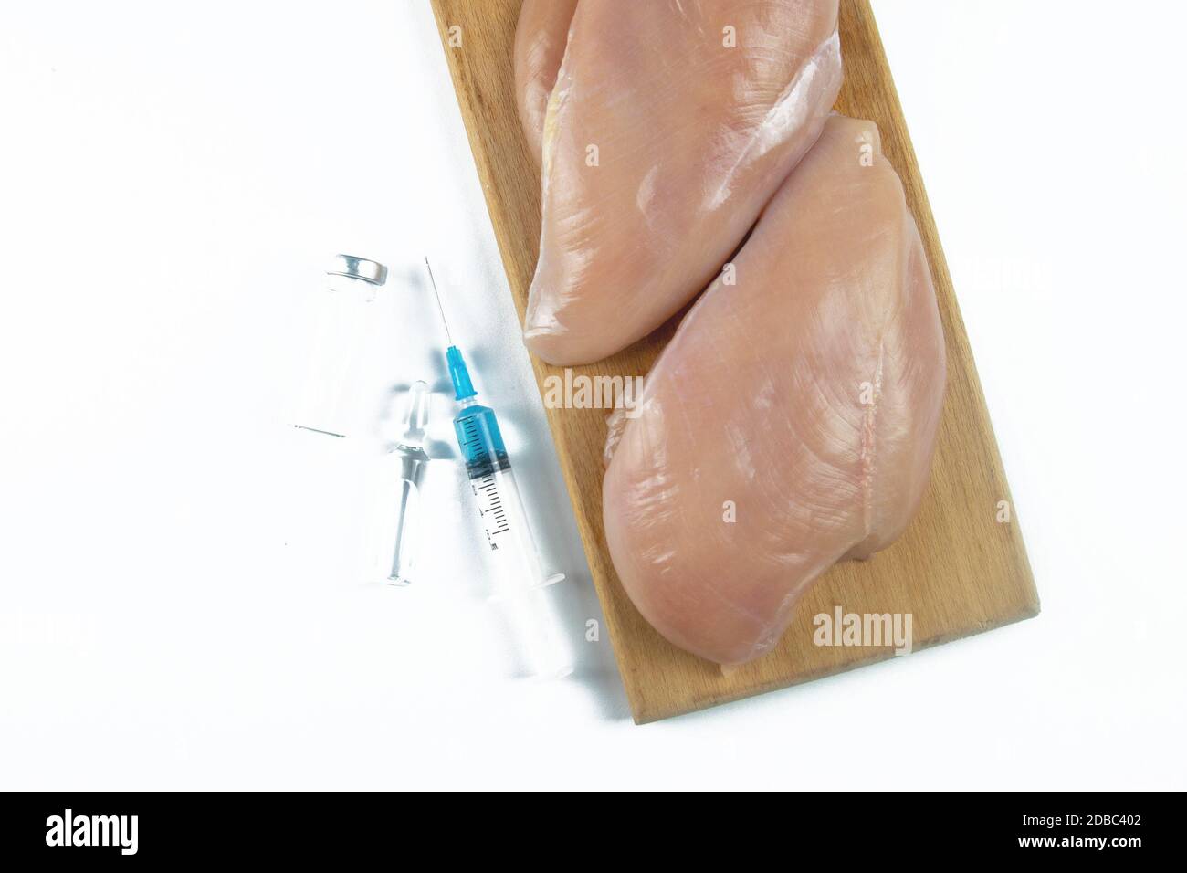 Syringe with liquid being injected to a piece of meat. Conceptual ...