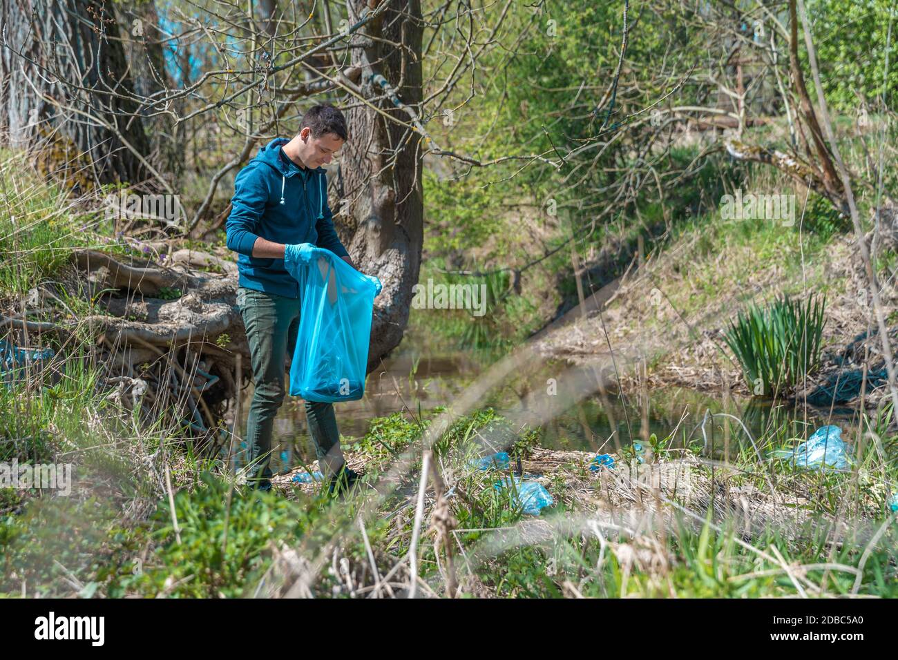collecting plastic in nature, cleaning forests and meadows Stock Photo ...