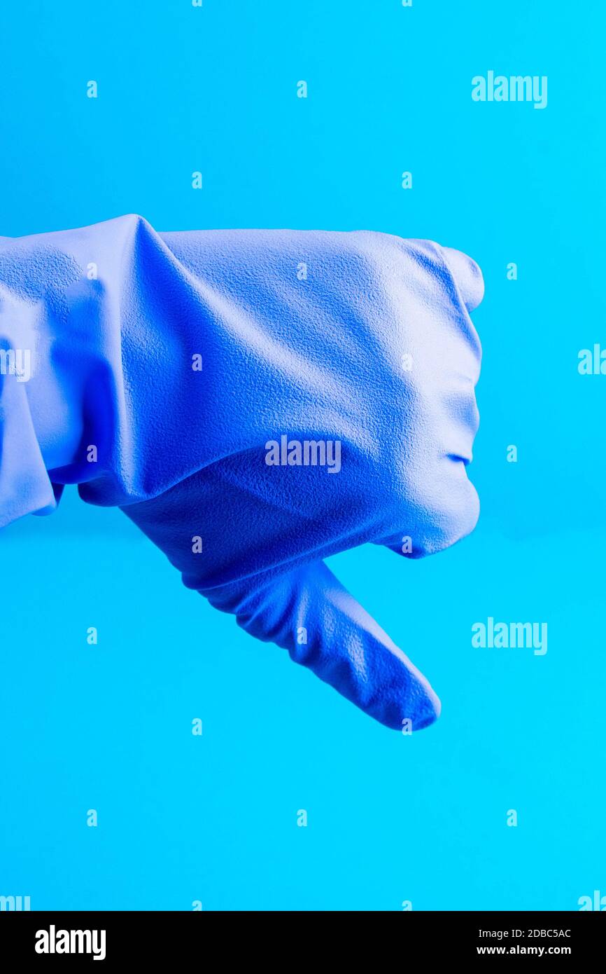 Doctor shows a gesture of dislike with his hand, wearing blue medical ...