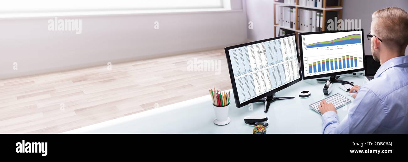 Analyst Looking At Data Table Report On Computer Desk Stock Photo - Alamy
