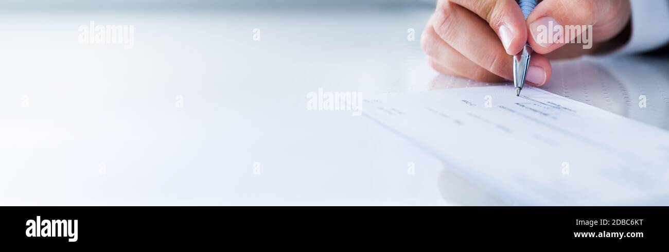 Hand Writing And Signing Compensation Pay Cheque Stock Photo - Alamy