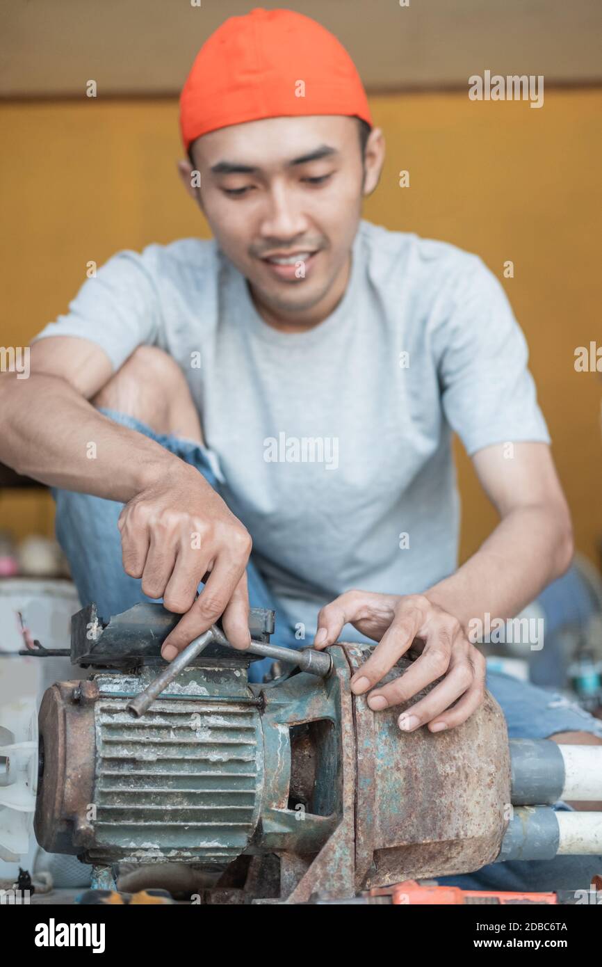 Man fixing water pump hi-res stock photography and images - Alamy