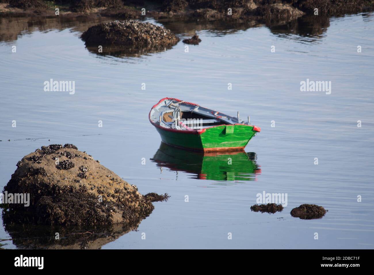 Green rowing boat moored on the seashore between rocks Stock Photo - Alamy