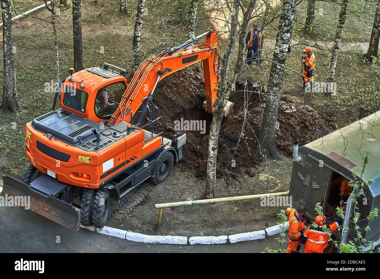 From above mini excavator digging a trench among the trees for ...