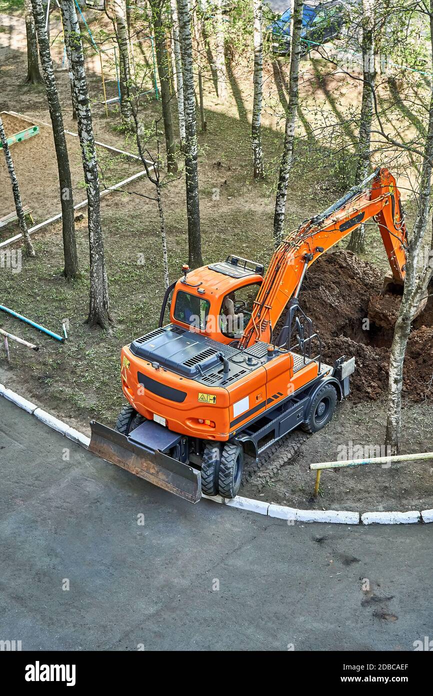 From above mini excavator digging a trench among the trees for ...