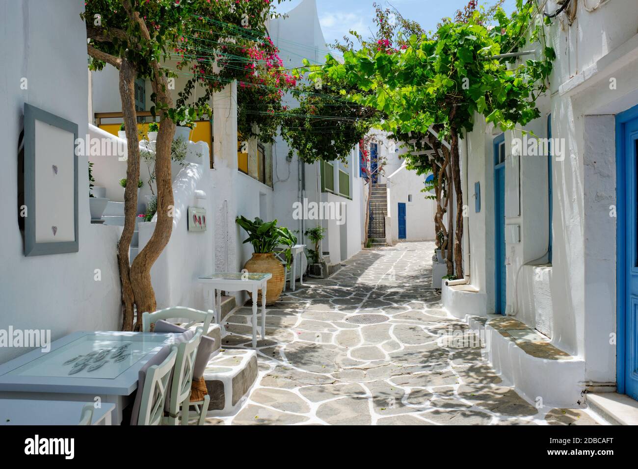 Picturesque narrow street with traditional whitewashed houses with cafe ...