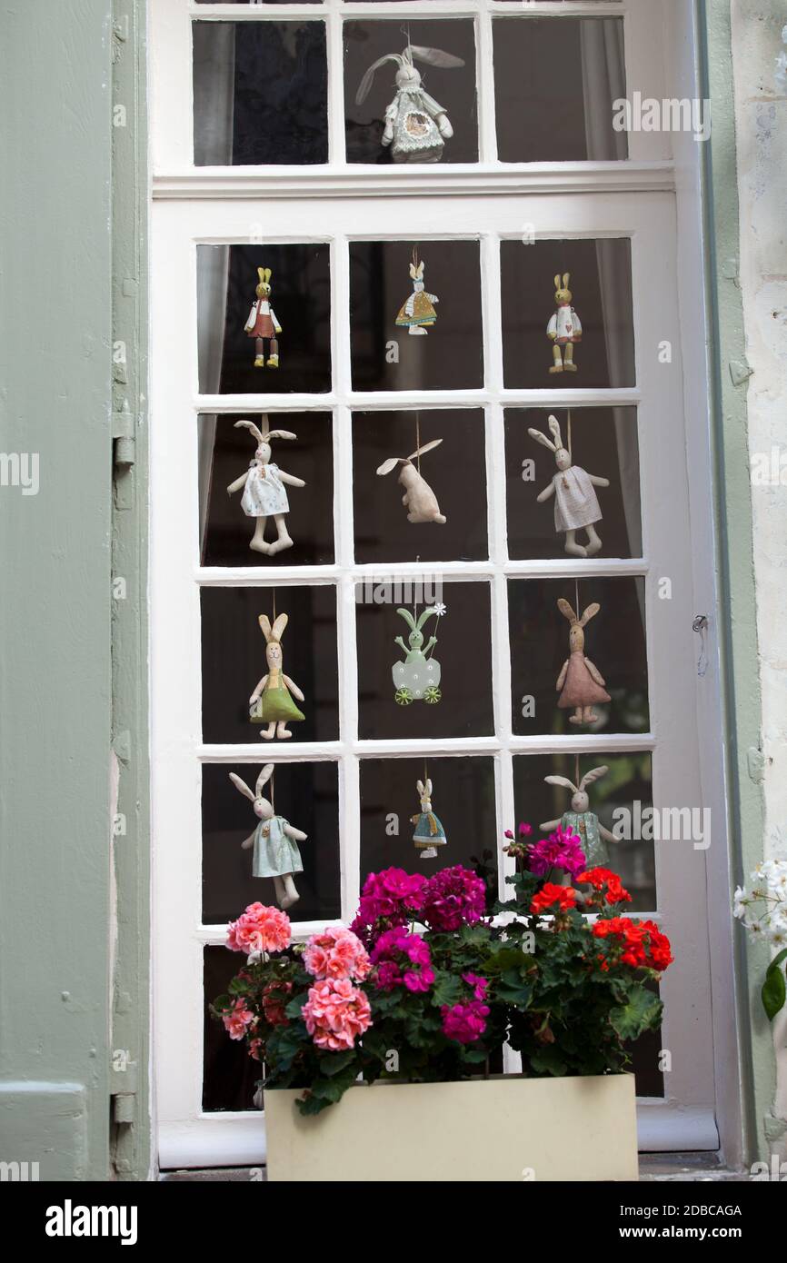 White window with flower pot and with funny hanging dollies Stock Photo ...