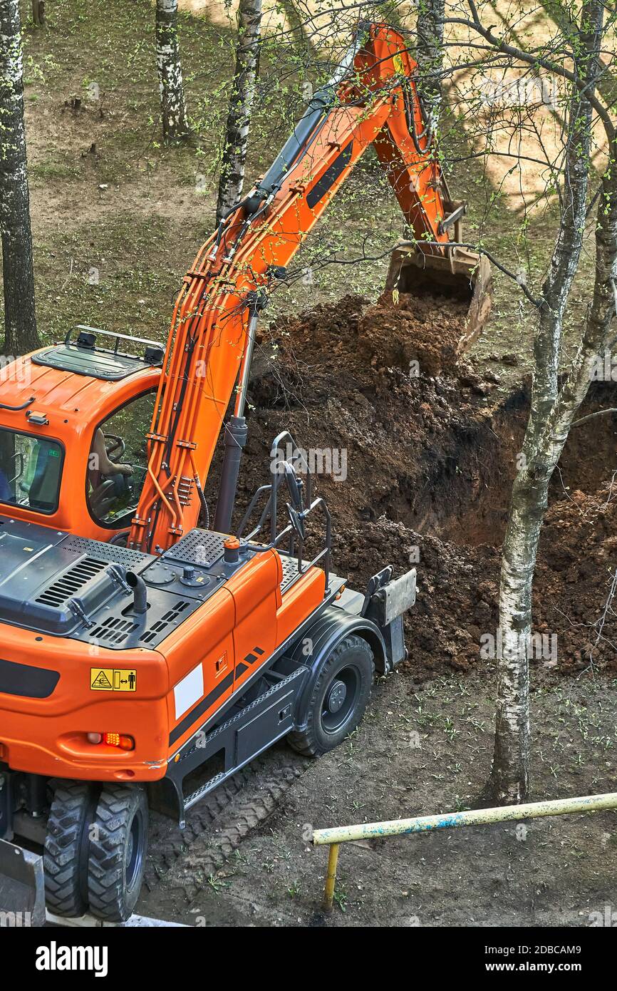 From above mini excavator digging a trench among the trees for ...
