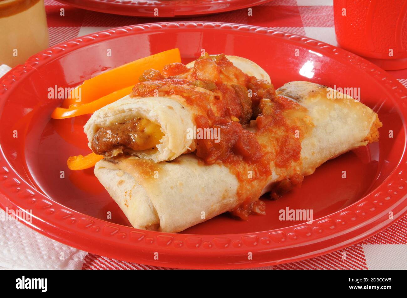 A plastic plate of burritos on a picnic table Stock Photo - Alamy
