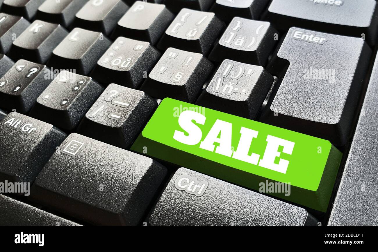 Black keyboard with one green key labeled by sale sign Stock Photo - Alamy