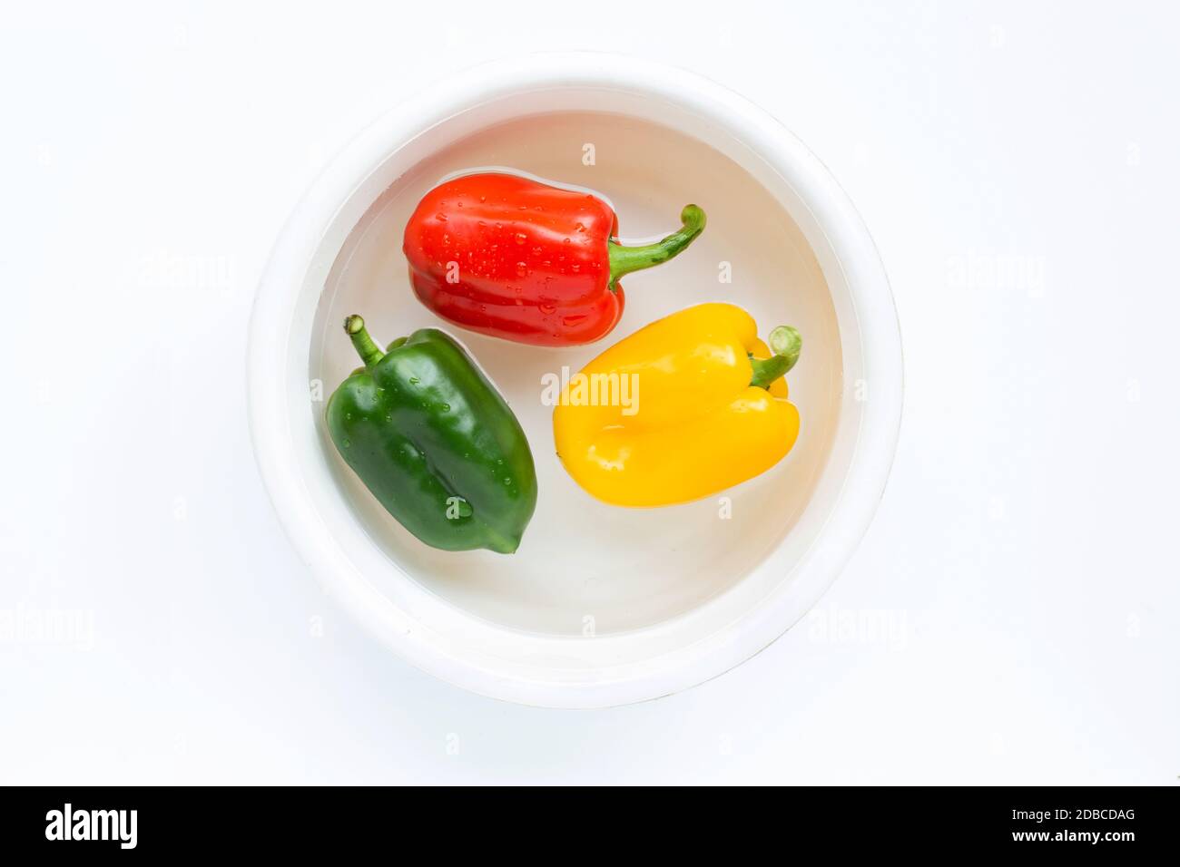 Bell pepper soaked in water. Washing fresh vegetables on white ...