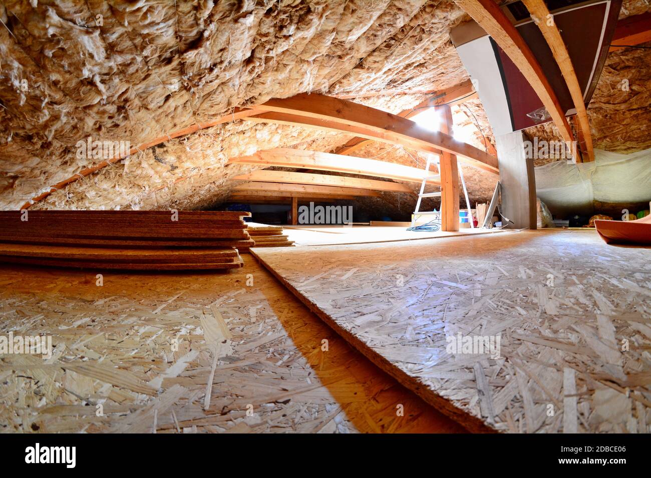 Empty house attic space with wood beams, wool roof insulation ...