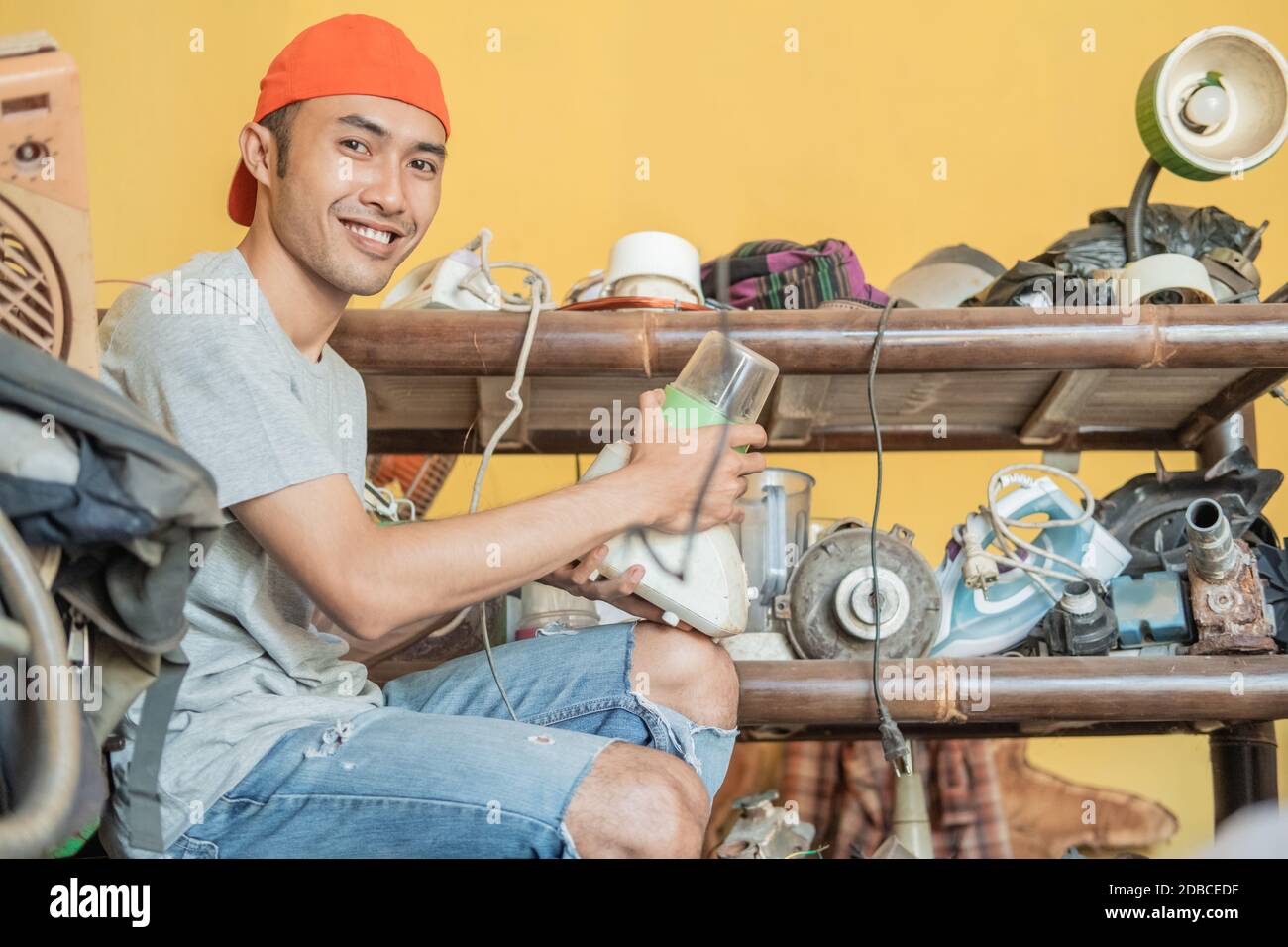 electronics repairman smiles at the camera as he installs a blender ...