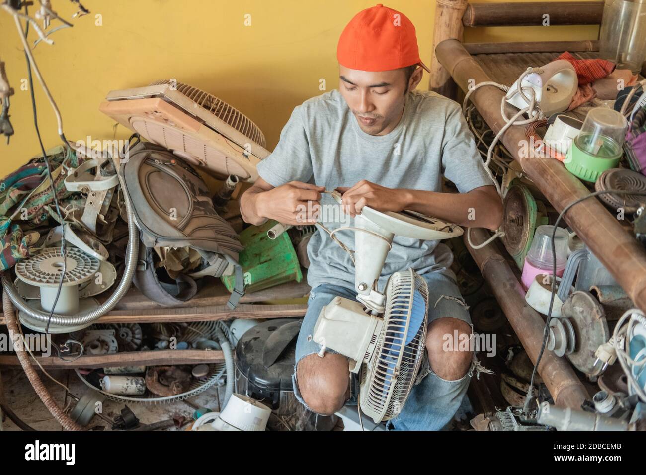 Electronics repairmen repair fan wiring while sitting around broken ...