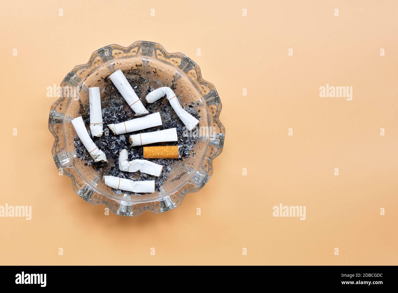 Smoked cigarettes on cream color background. Copy space Stock Photo - Alamy