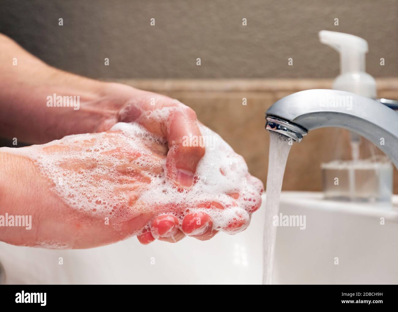 Washing hands with soap and water in bathroom sink, protection against ...