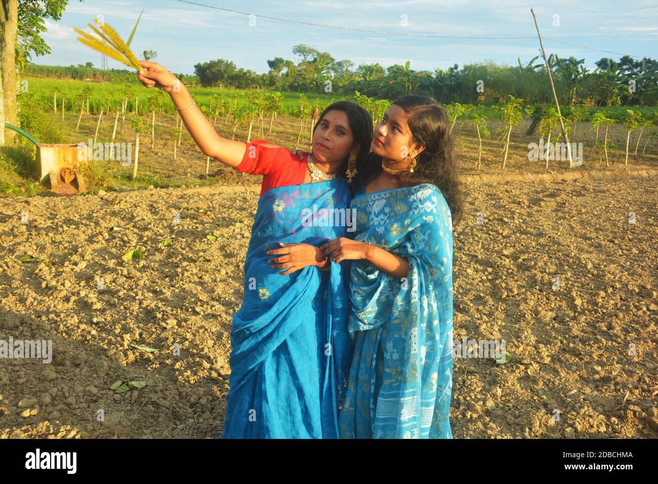 Close up of two Indian Bengali girls wearing blue sari and golden ...