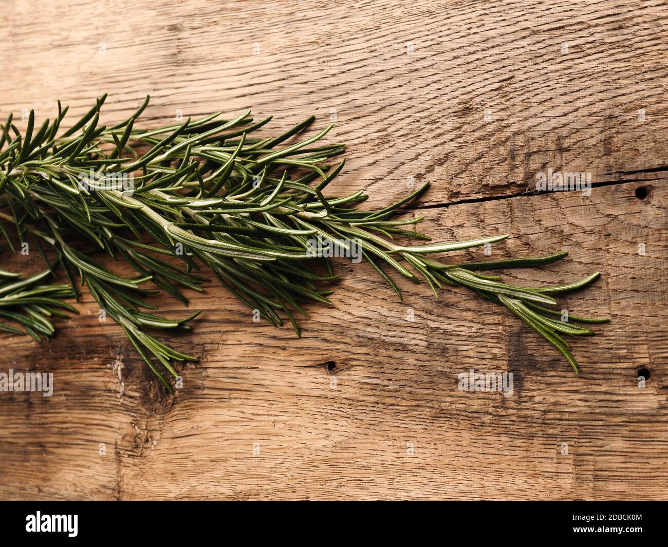 Twig of organic rosemary on a rustic wooden kitchen table, healthy food ...