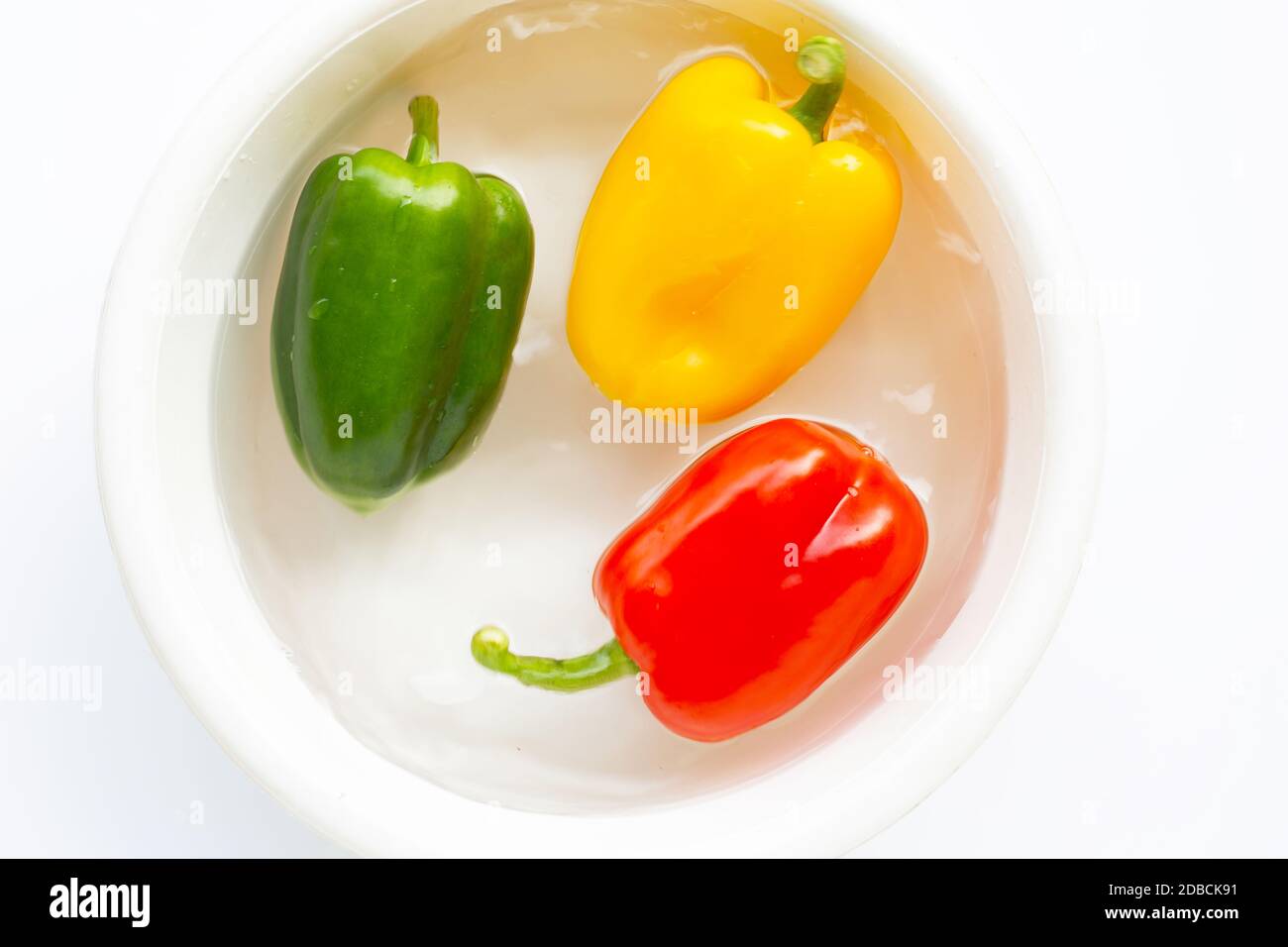 Bell pepper soaked in water. Washing fresh vegetables on white ...
