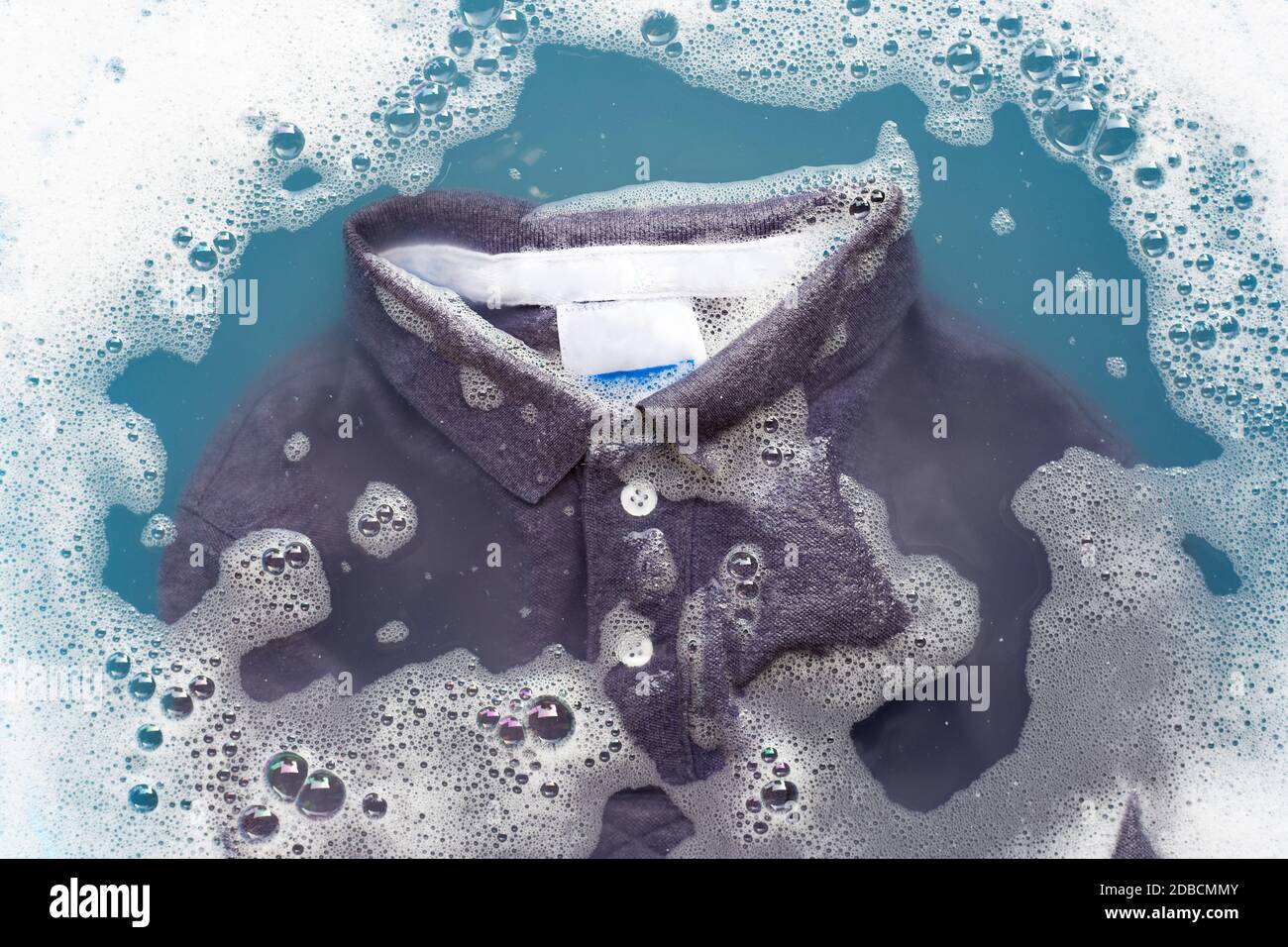 Grey polo shirt soak in powder detergent water dissolution, washing ...