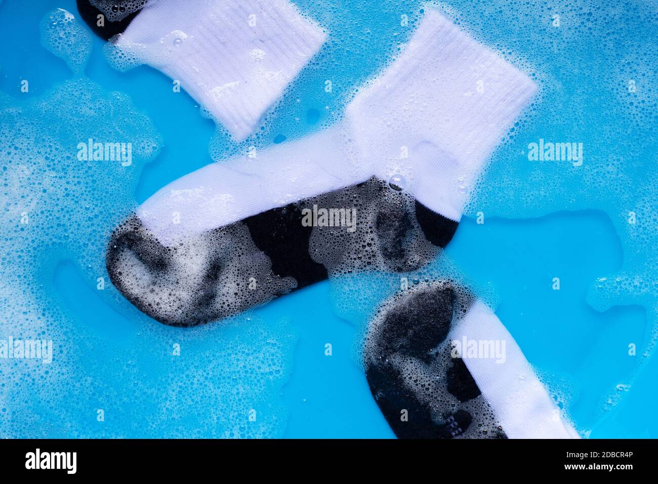 Dirty socks soaking in powder detergent water dissolution. Laundry ...