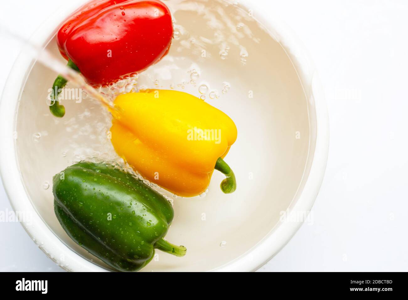 Bell pepper soaked in water. Washing fresh vegetables on white ...