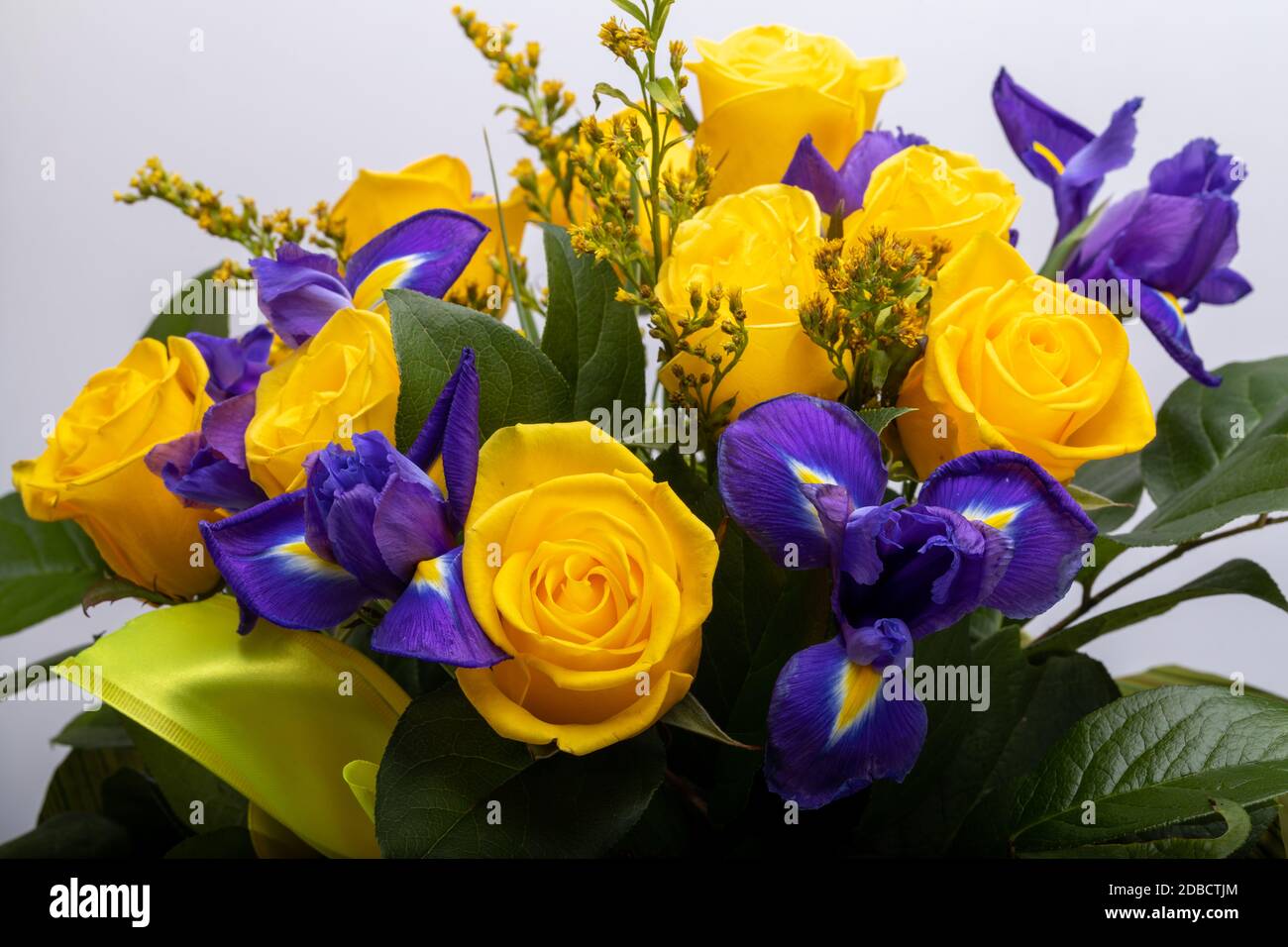 beautiful floristic bouquet of blue irises and yellow roses Stock Photo ...