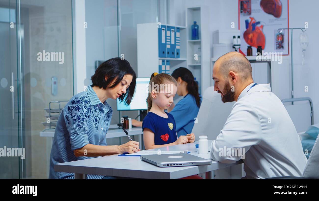 Mother completing a medical questionnaire with daughter data in medical ...