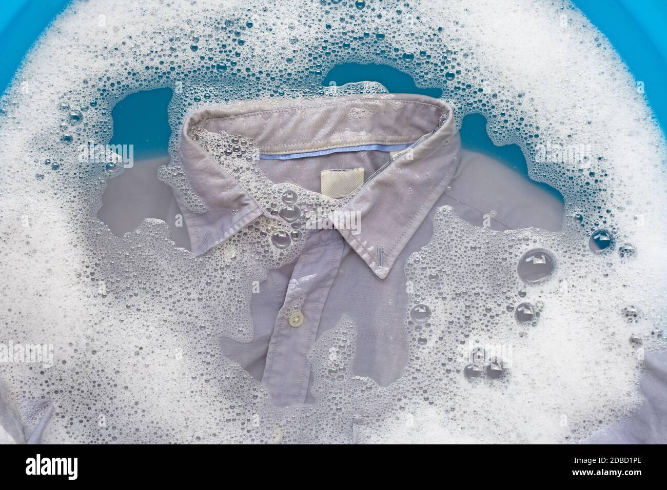 Grey shirt soak in powder detergent water dissolution, washing cloth ...
