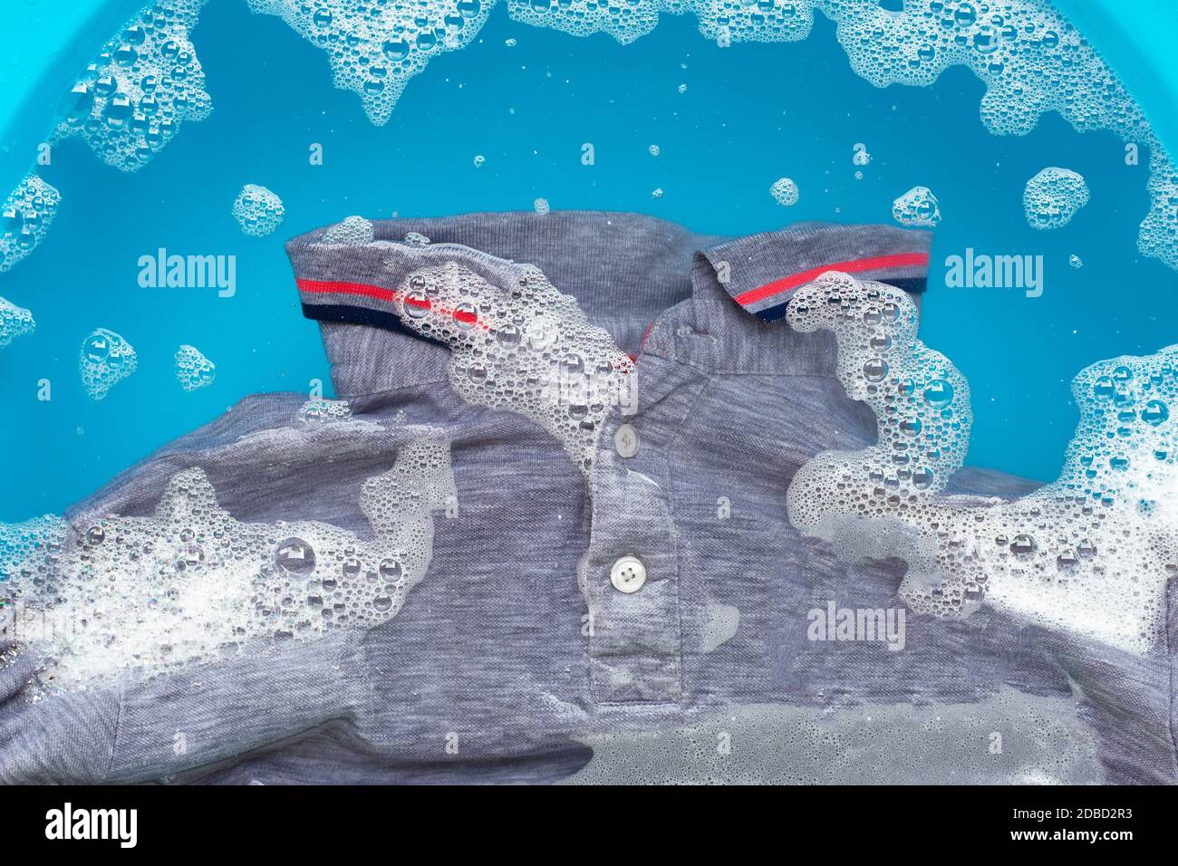 Grey polo shirt soak in powder detergent water dissolution, washing ...