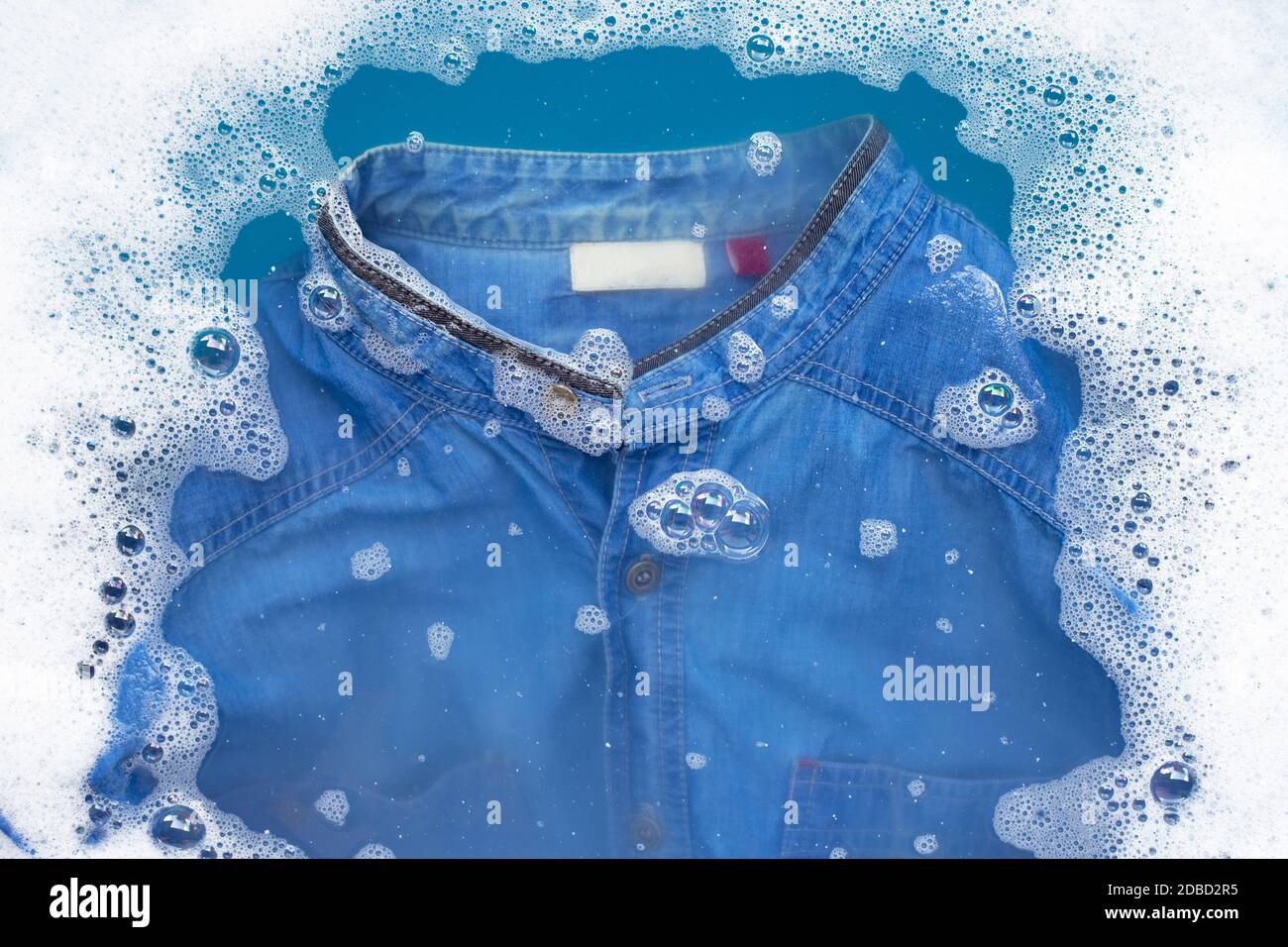 Jean shirt soak in powder detergent water dissolution, washing cloth ...