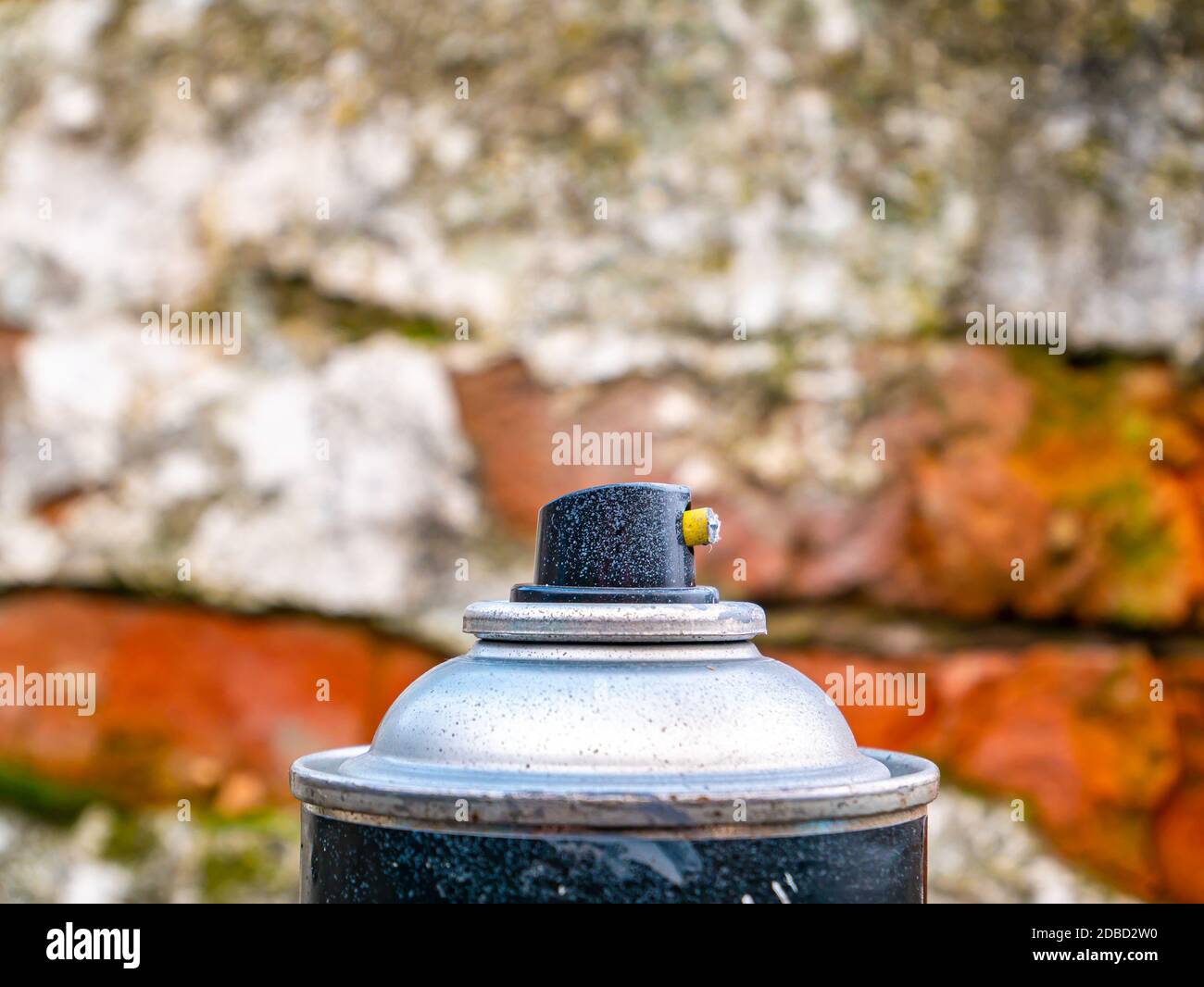 Black button of spray paint on a brick wall background. Aerosol spray ...