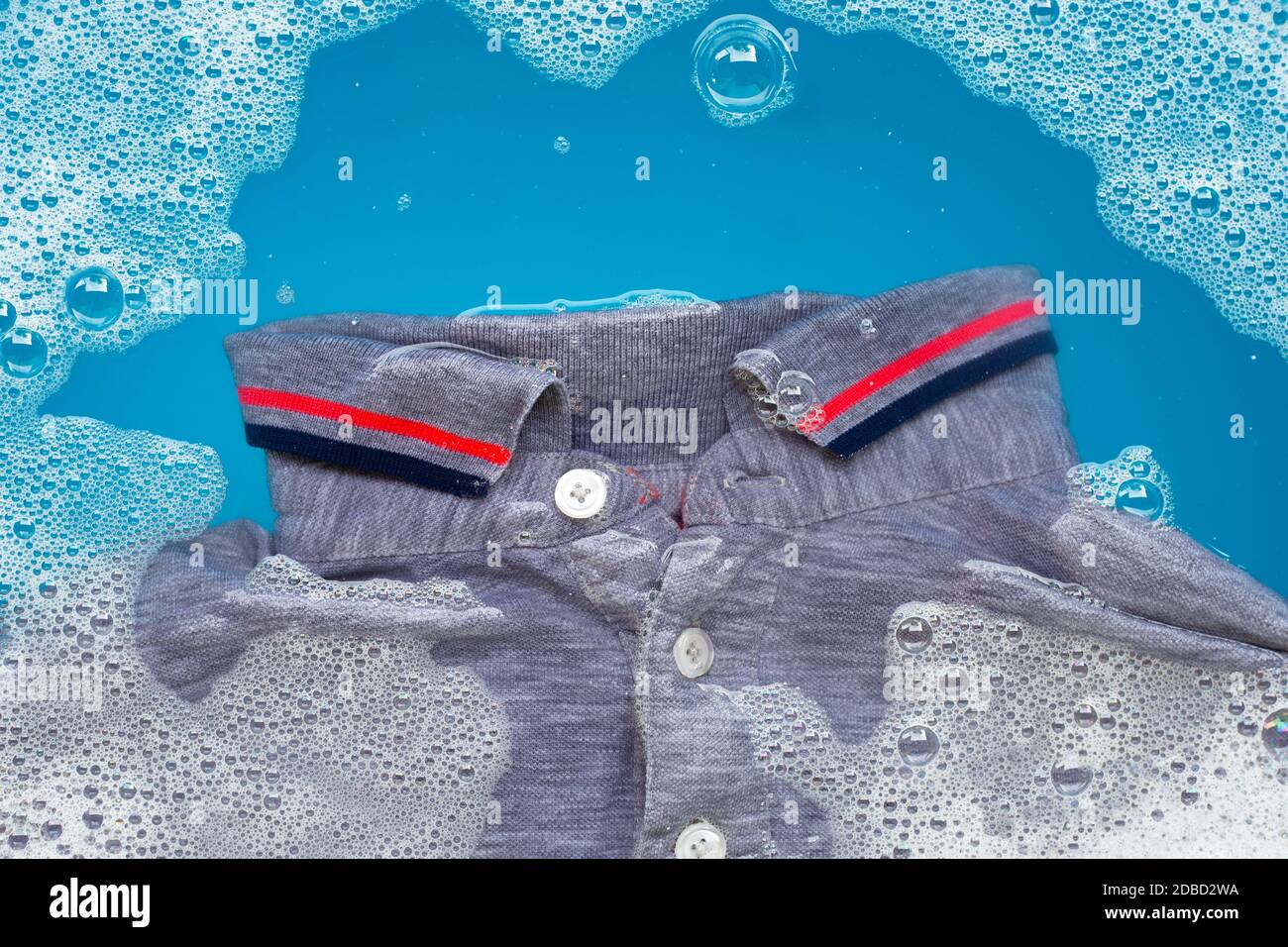 Grey polo shirt soak in powder detergent water dissolution, washing ...