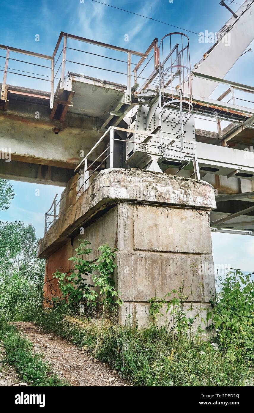 Reinforced concrete bridge support. Iron train bridge over the river ...