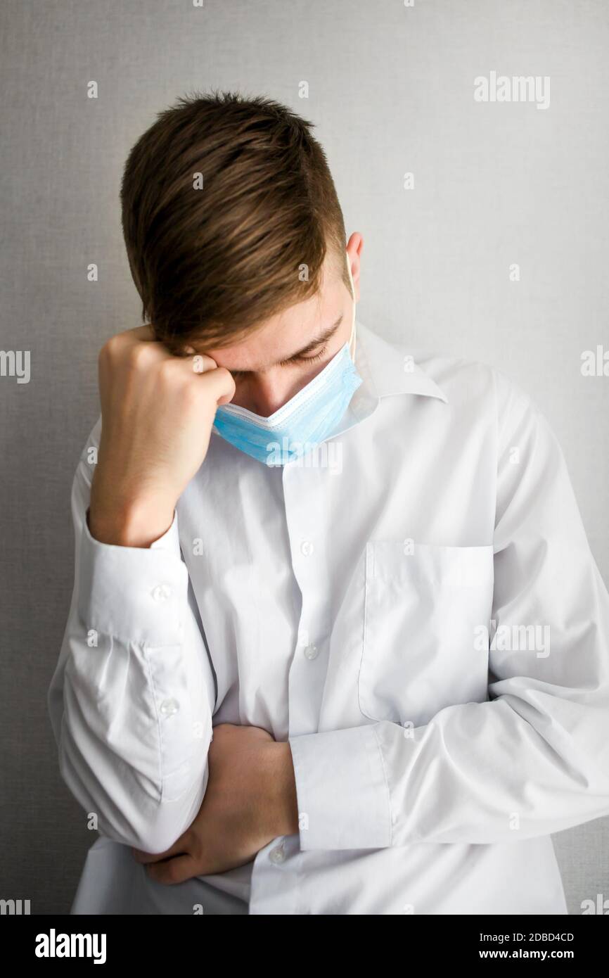 Sad and Tired Young Man in a Flu Mask by the Wall in the Room Stock ...
