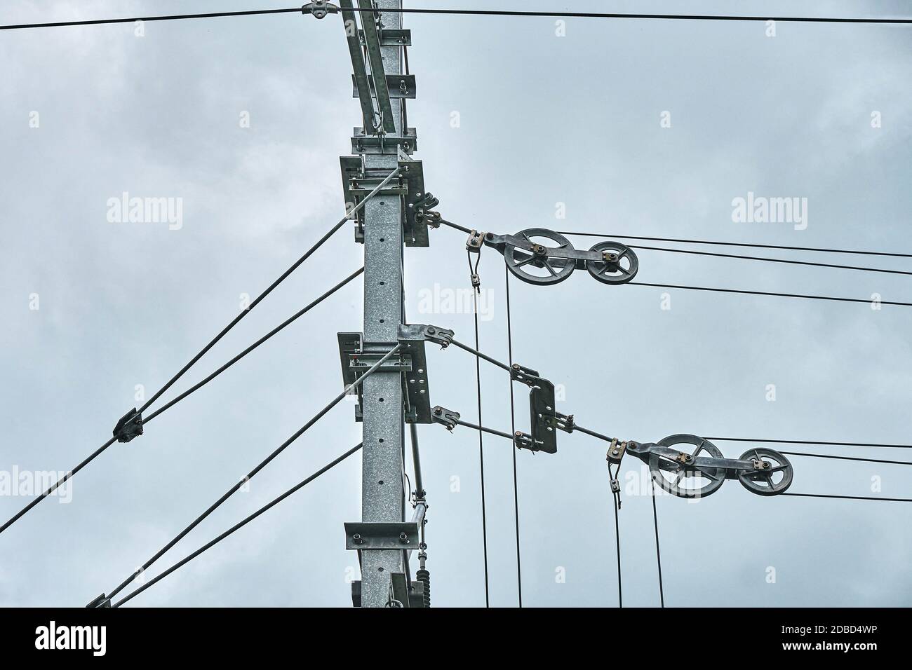 Overhead contact wires of electrified railway tracks against a gloomy ...