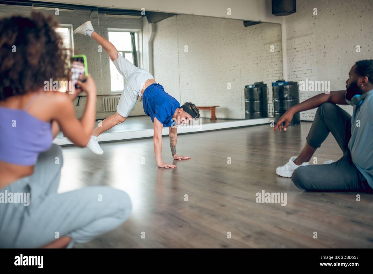 Dance teacher teaches his student to do handstand Stock Photo - Alamy