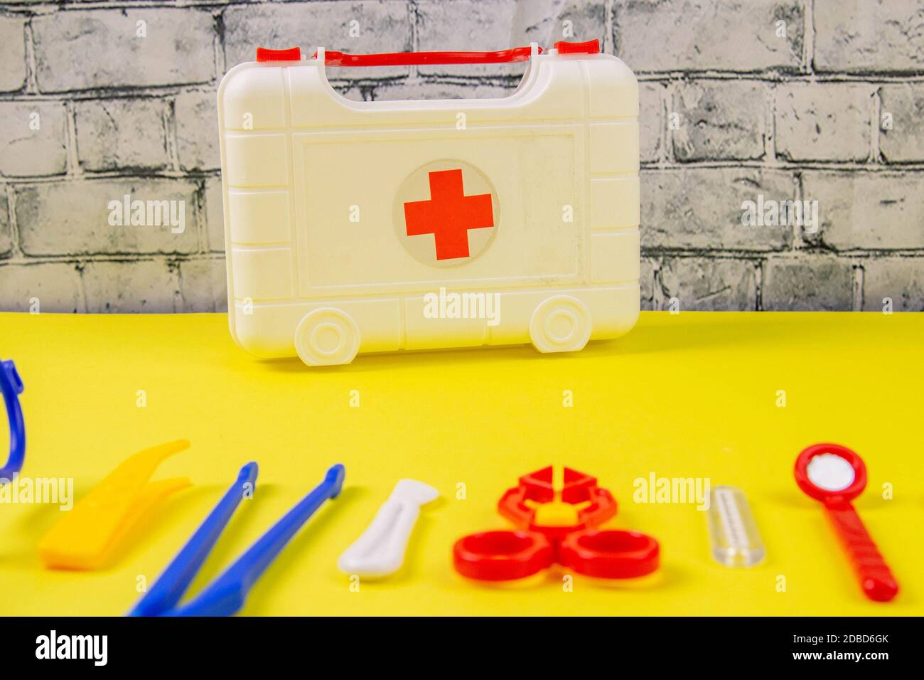 Toy - First aid kit on yellow table. Set of little doctor. Close-up ...