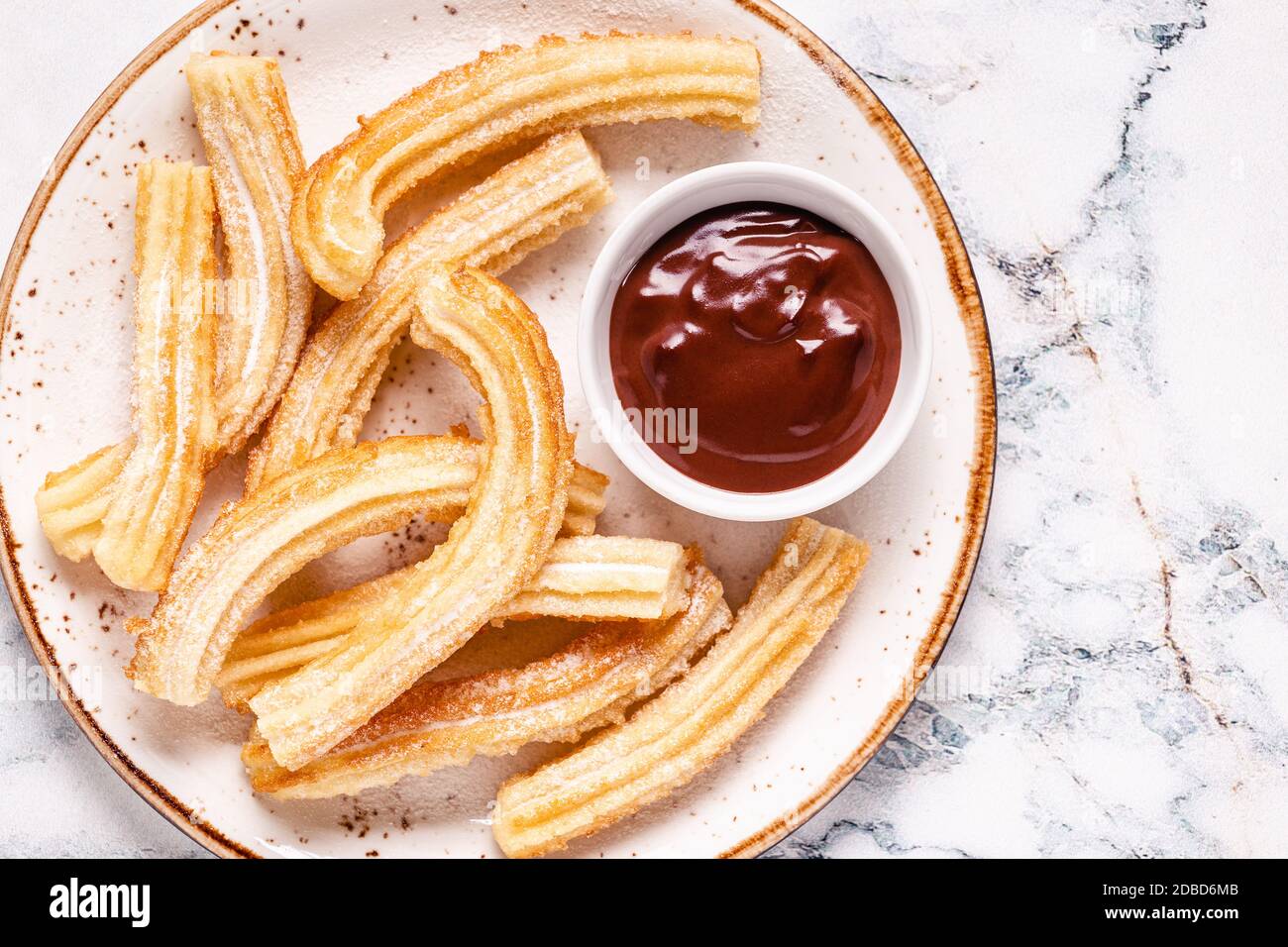 Churros with powdered sugar and chocolate sauce, top view Stock Photo ...