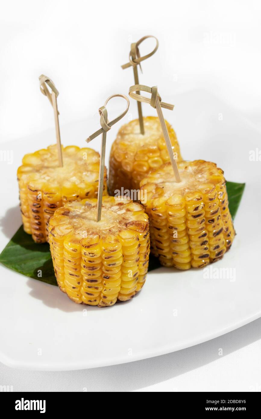 organic sweet corn on the cob vegan tapas snack food on white table ...
