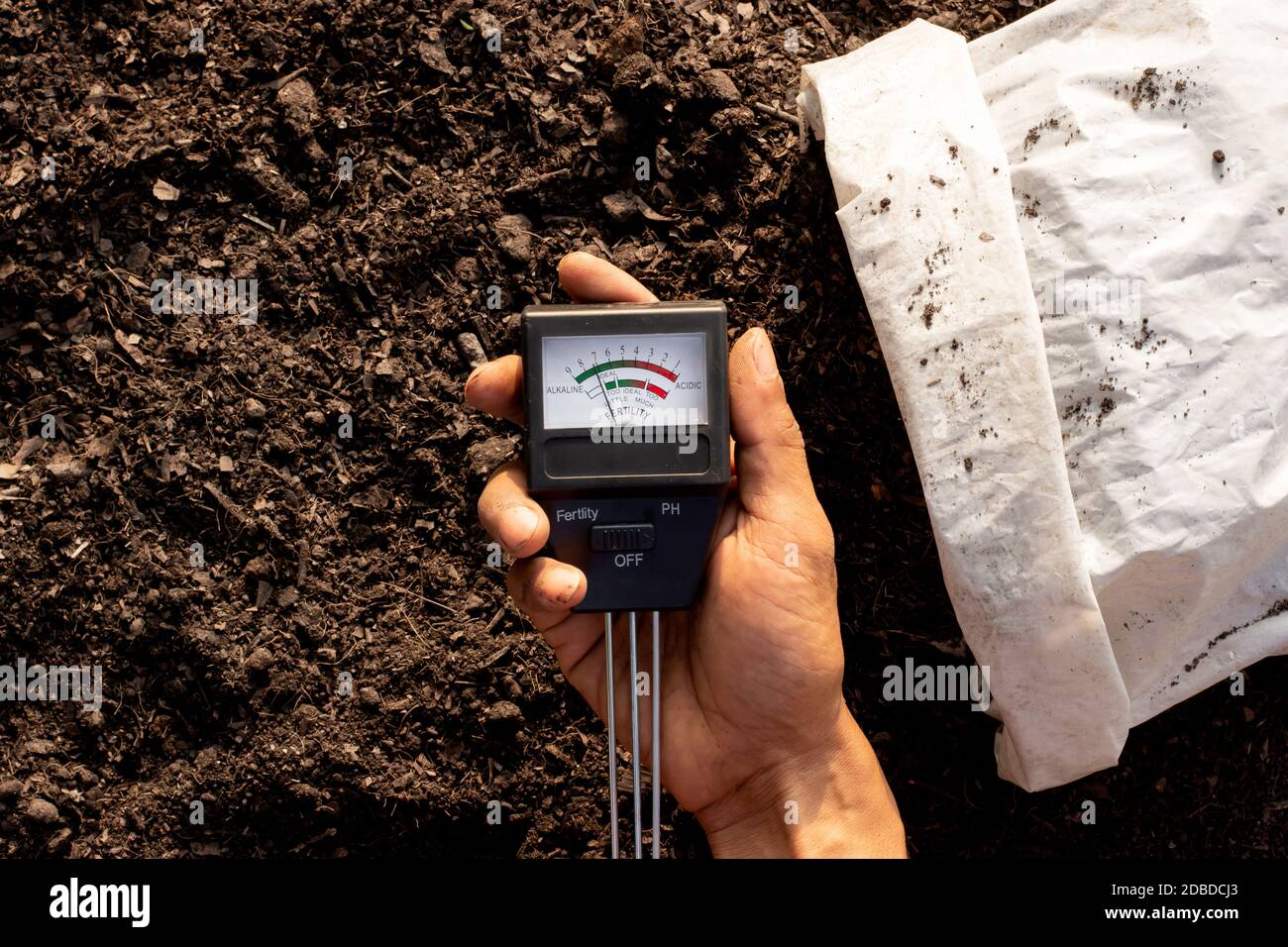 Soil quality meter in the hands of a man who is checking the soil for ...