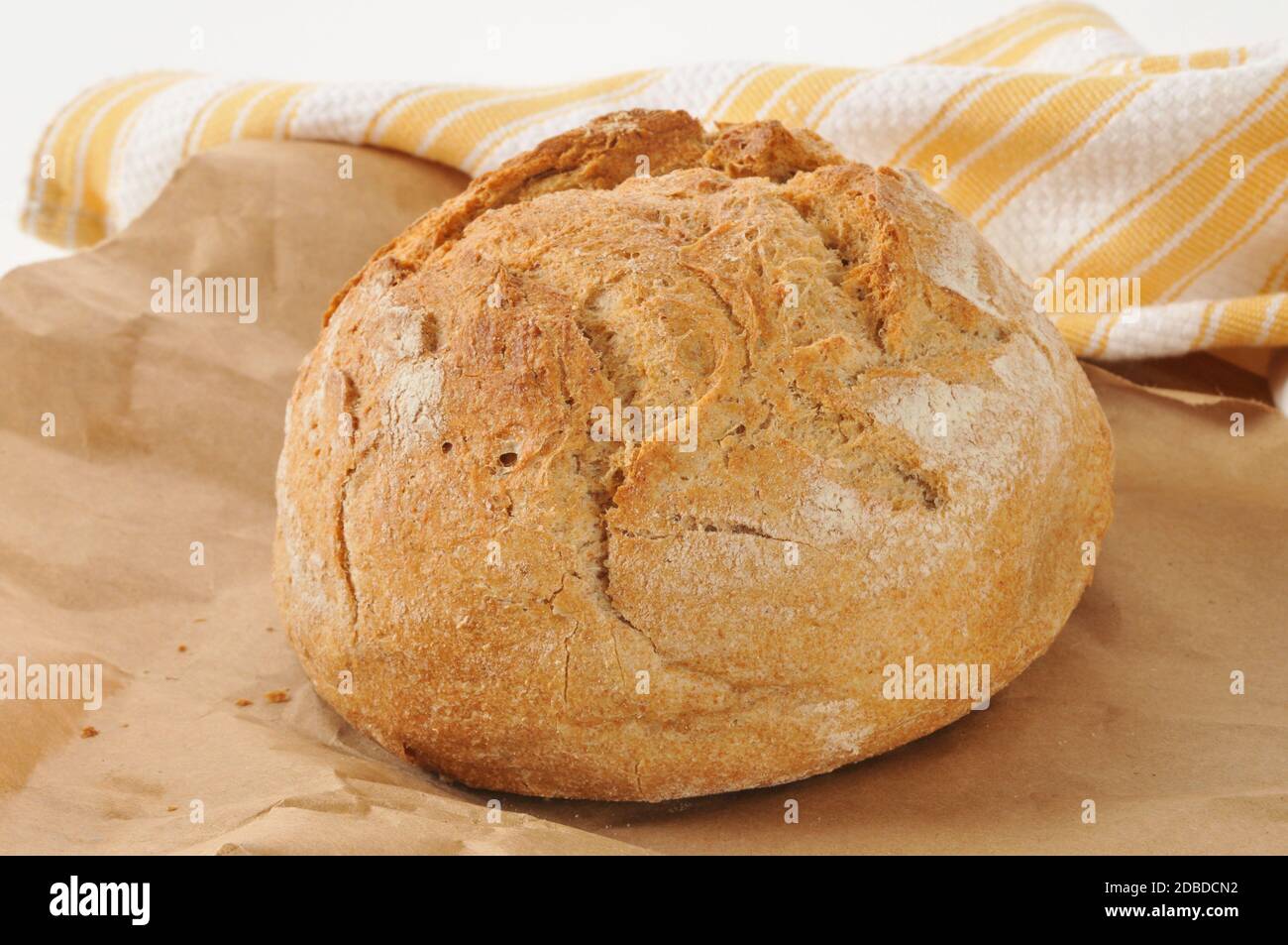 A loaf of artisan whole wheat bread in brown paper wrapping Stock Photo ...