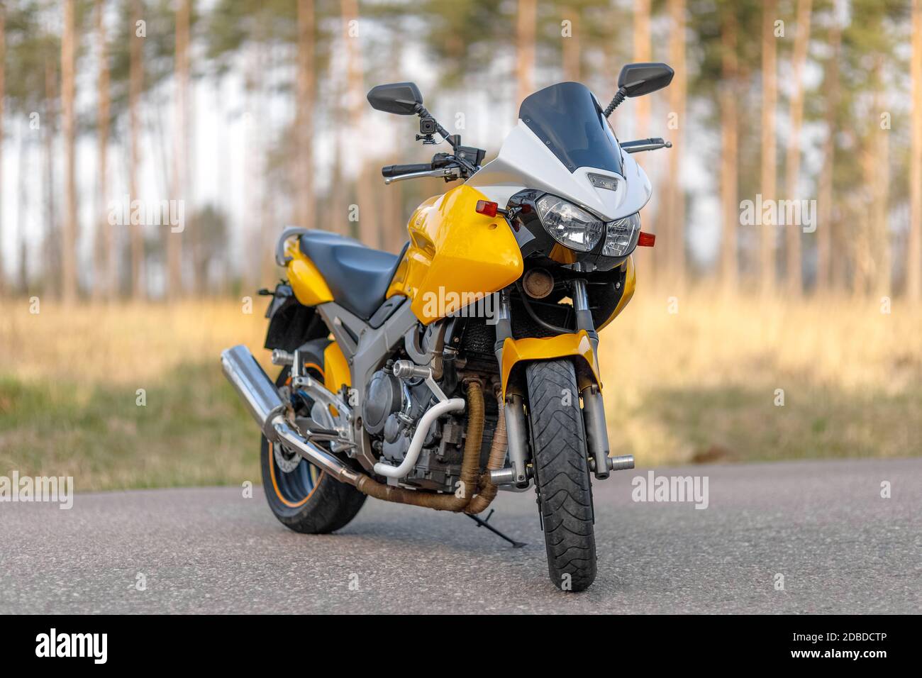 Yellow motorcycle on the road in the forest zone, front-side view Stock ...